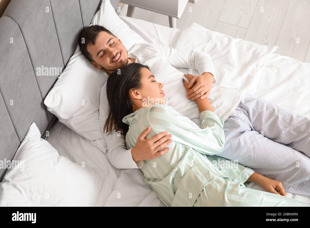 Young woman with her husband sleeping on bed, top view Stock Photo - Alamy