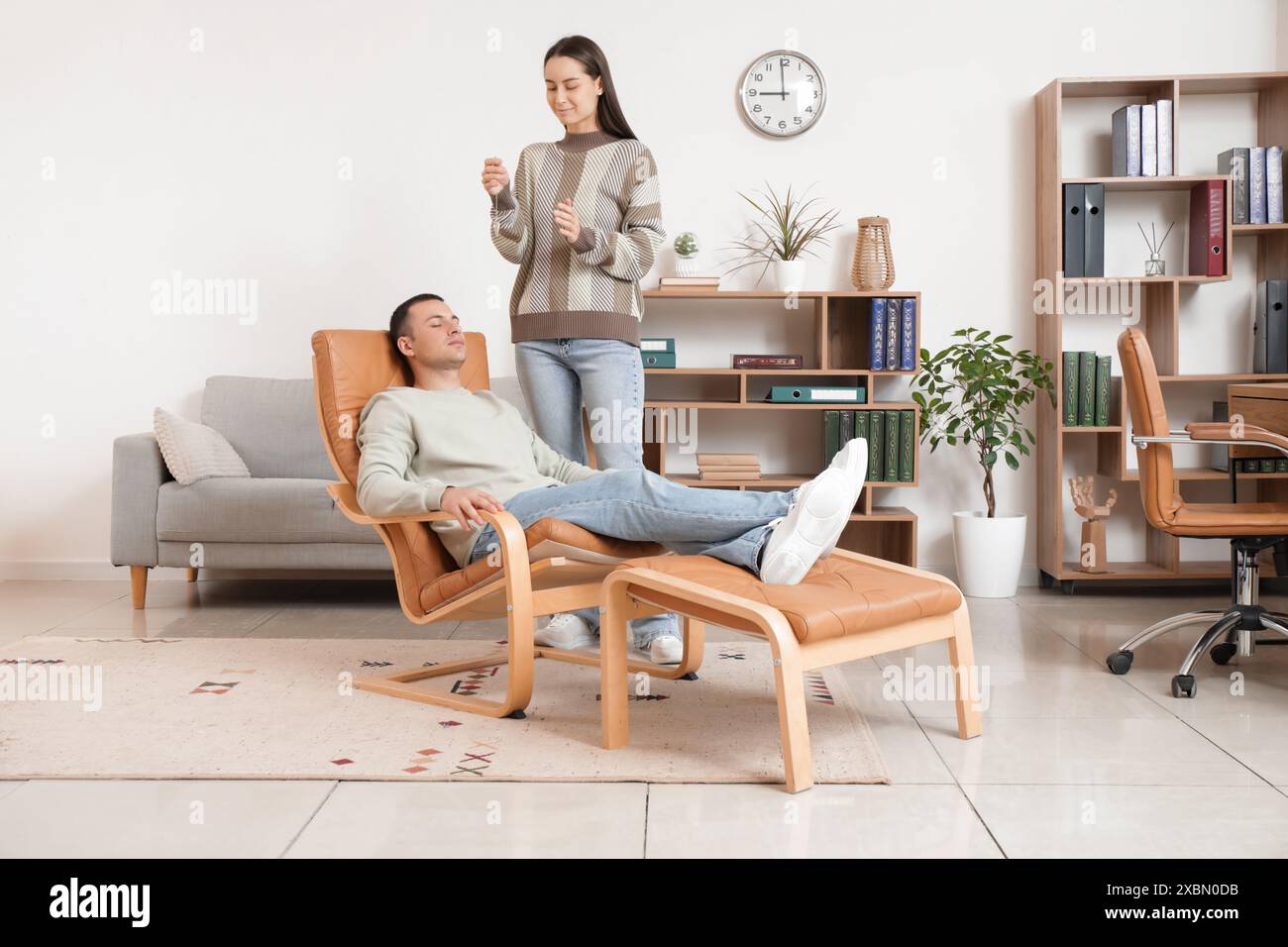 Female psychologist with pendulum hypnotizing man in office Stock Photo ...