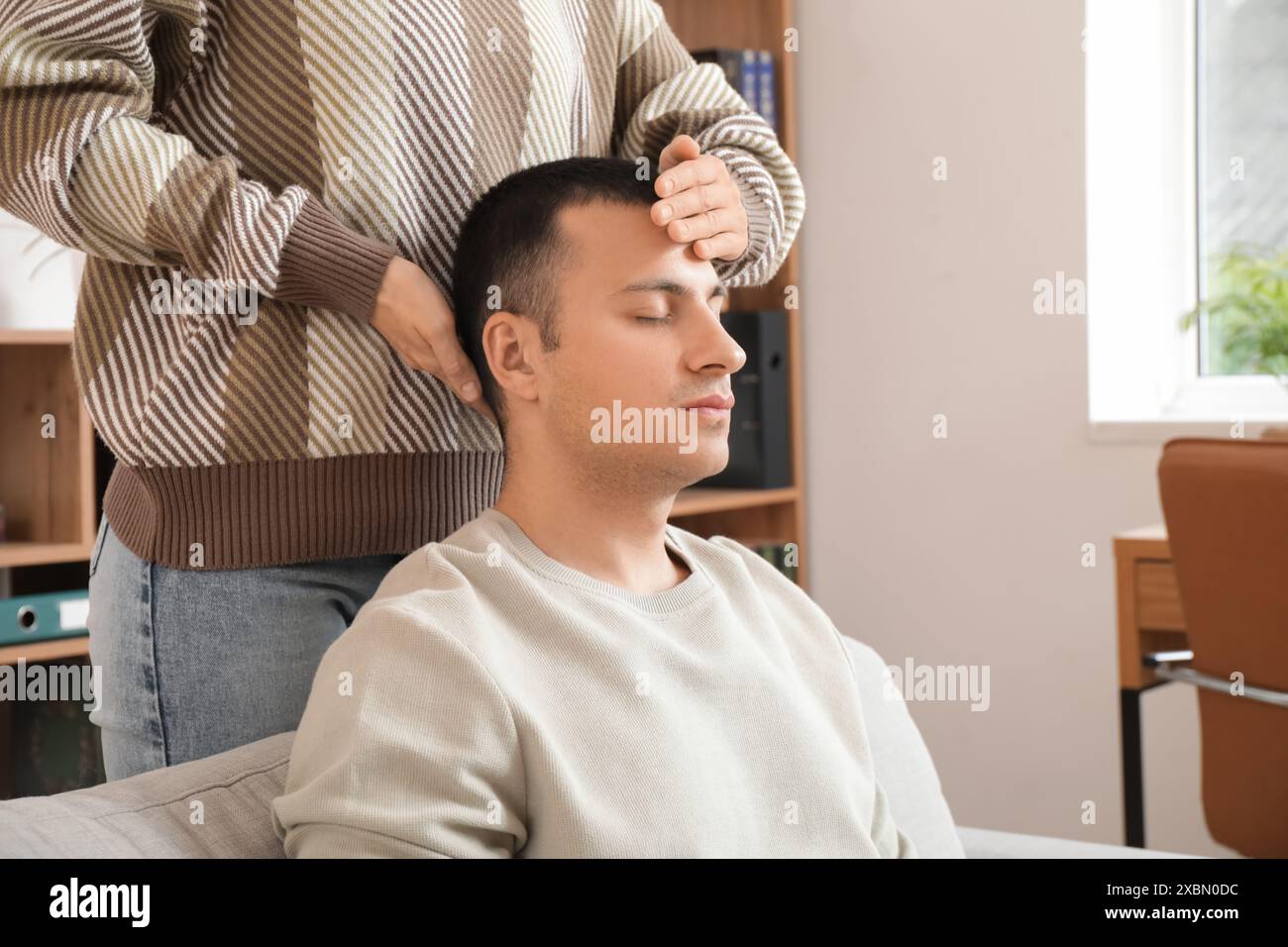 Female psychologist hypnotizing man in office Stock Photo - Alamy
