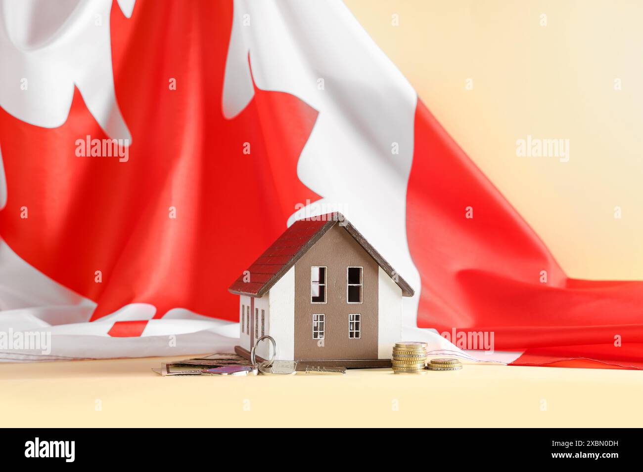 Figure of house, keys, money and Canadian flag on color background ...