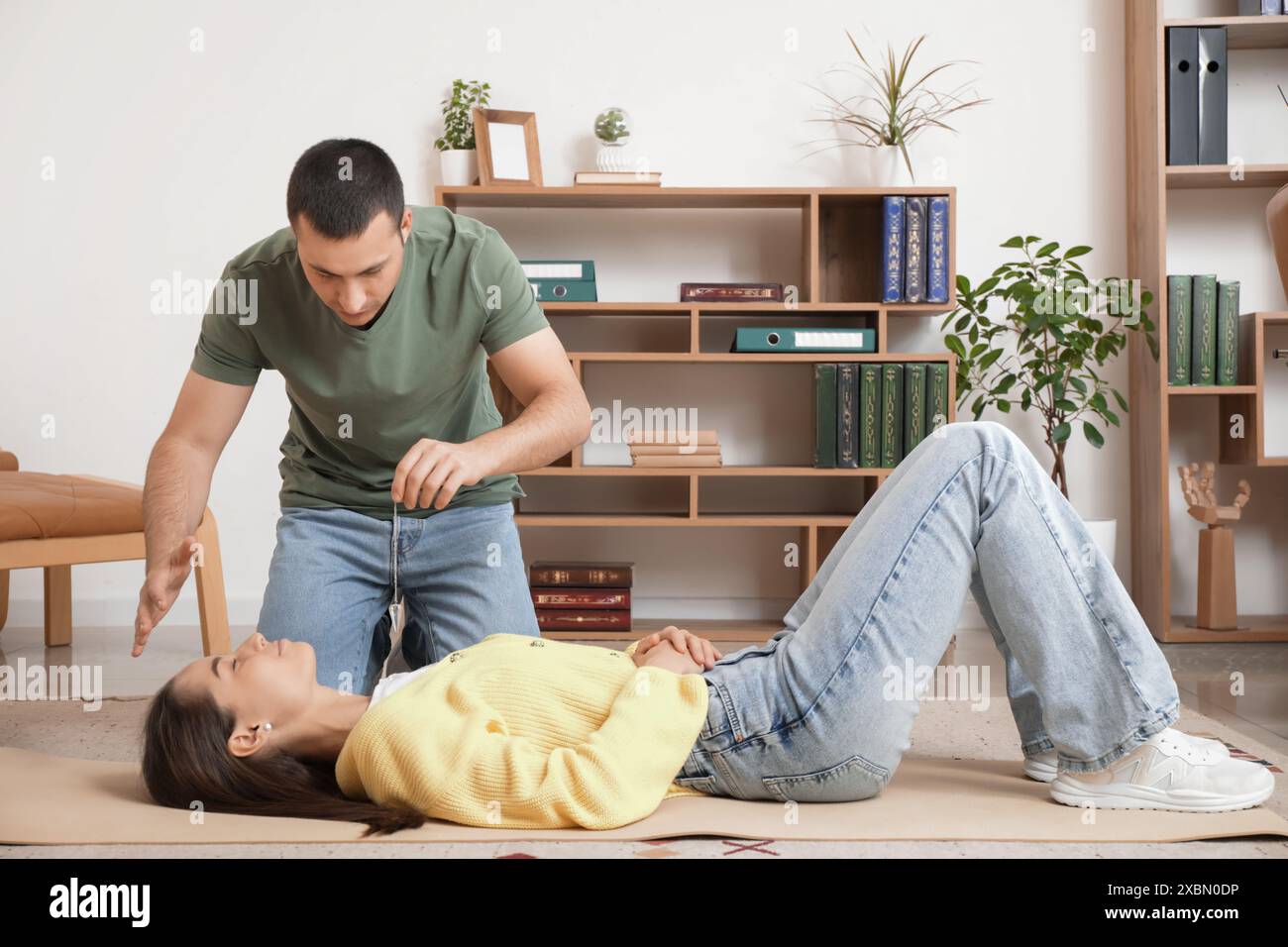 Male psychologist with pendulum hypnotizing woman in office Stock Photo ...
