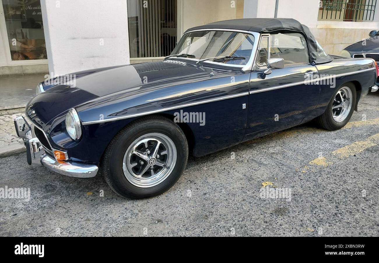 Dark blue 1970-s MG MGB roadster parked by the curbside, front left ...