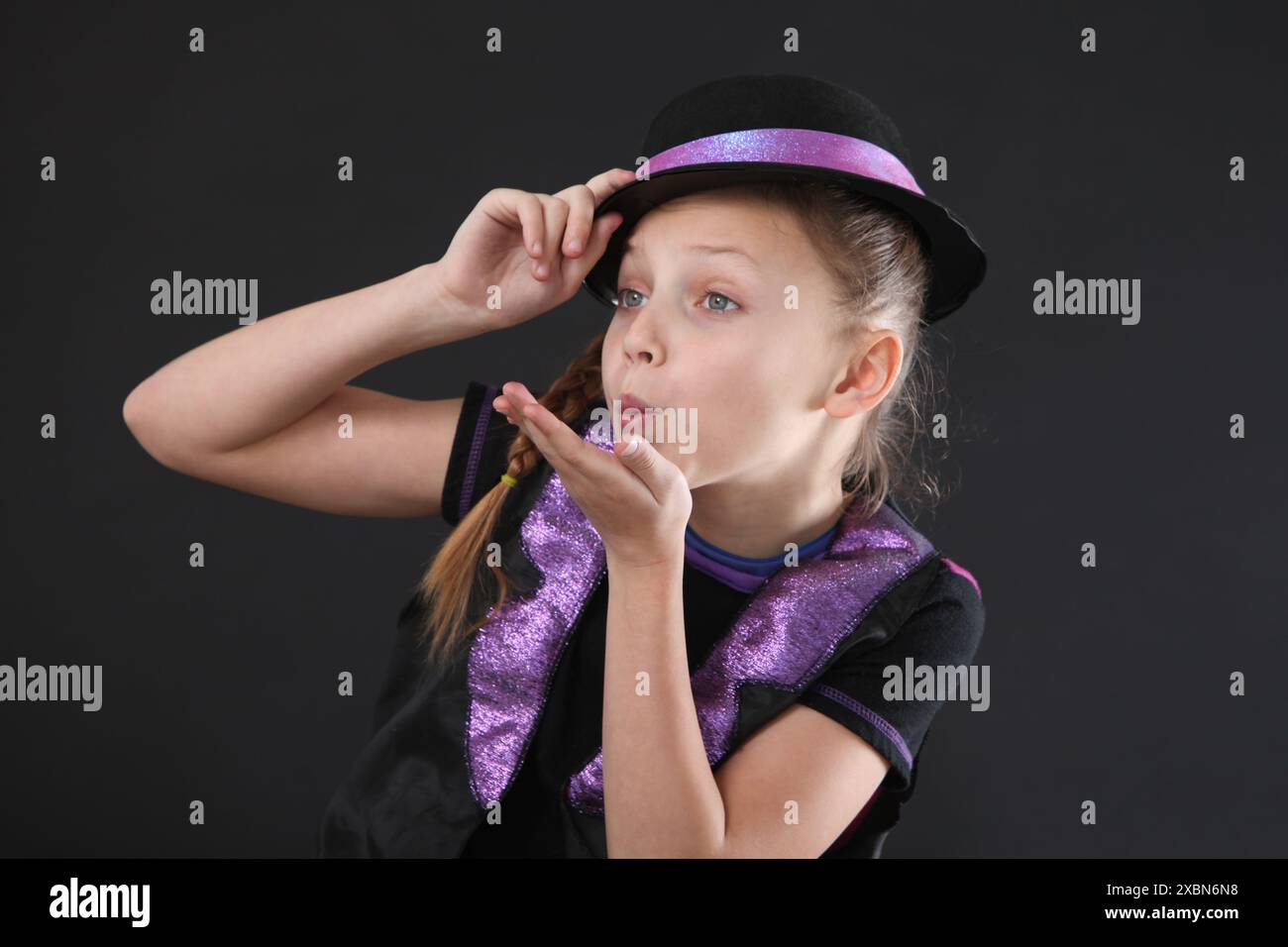 portrait of a happy girl in the studio on a black background, dressed ...