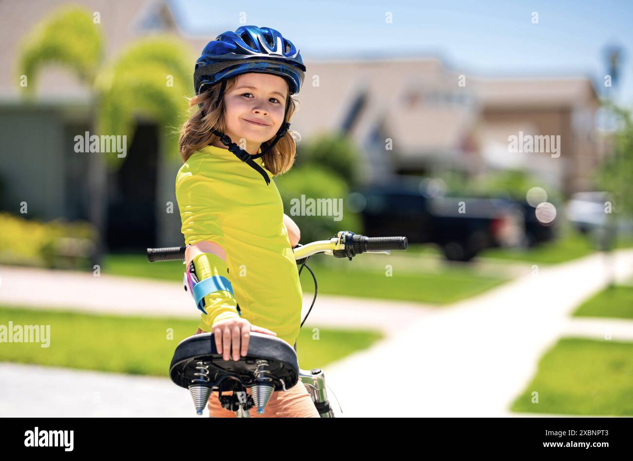 Kid riding bike in a helmet. Child riding bike in protective helmet ...