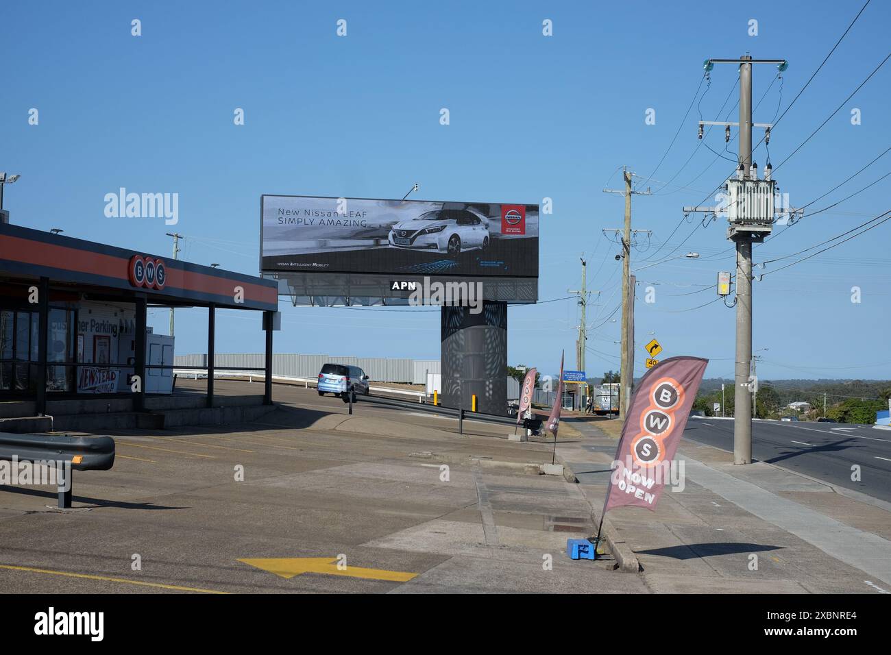 Drive-in bottle shop car park, electronic billboard and tall power ...
