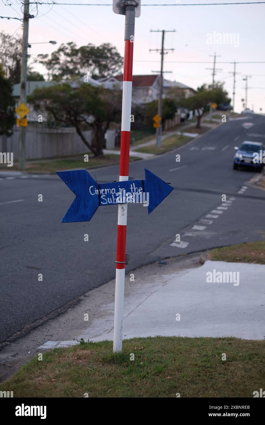 A handmade sign, an arrow painted blue inscribed Cinema In The Suburbs ...