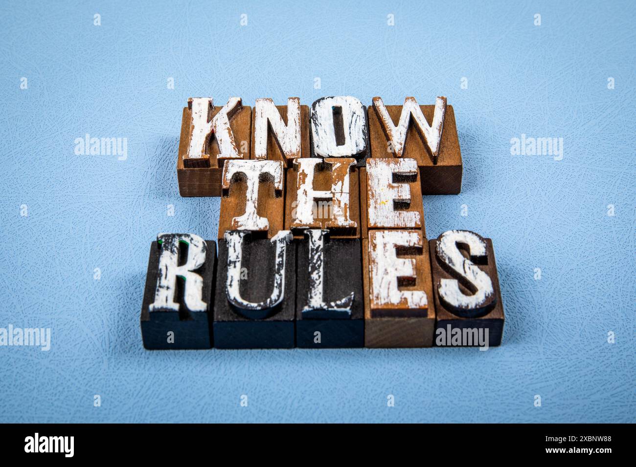 KNOW THE RULES. Wooden alphabet letter blocks on blue textured ...