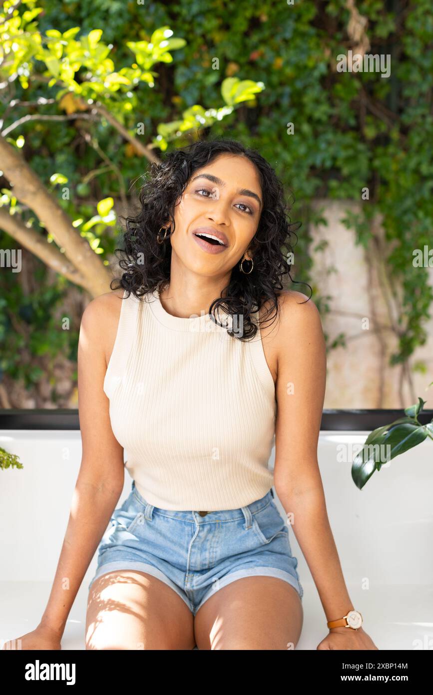Young Asian woman sitting outdoors, smiling brightly Stock Photo - Alamy