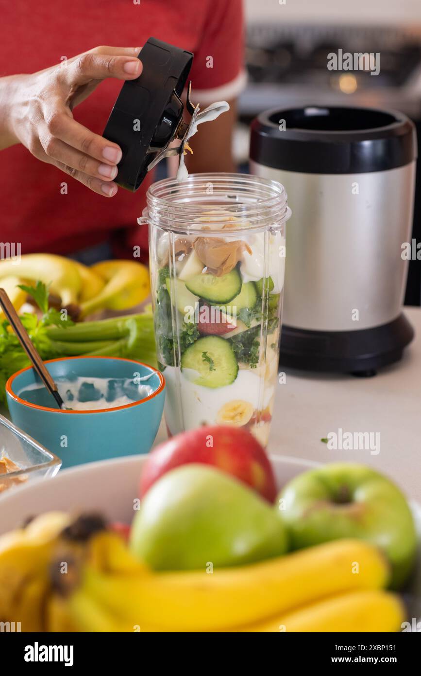 Young Asian woman preparing healthy smoothie with fresh fruits and ...
