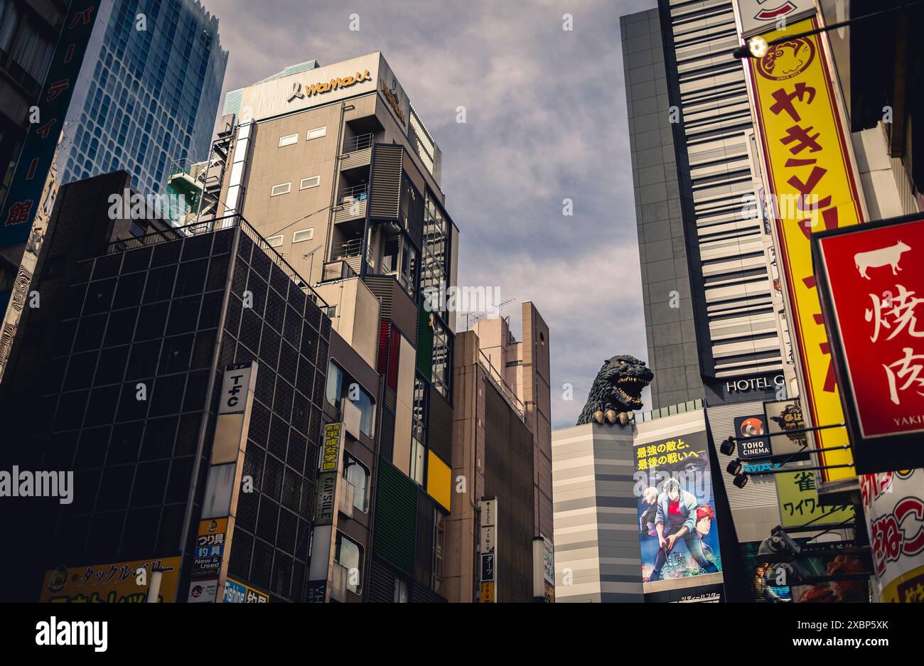 Urban scene in Shinjuku, Tokyo featuring the iconic Godzilla head on a ...