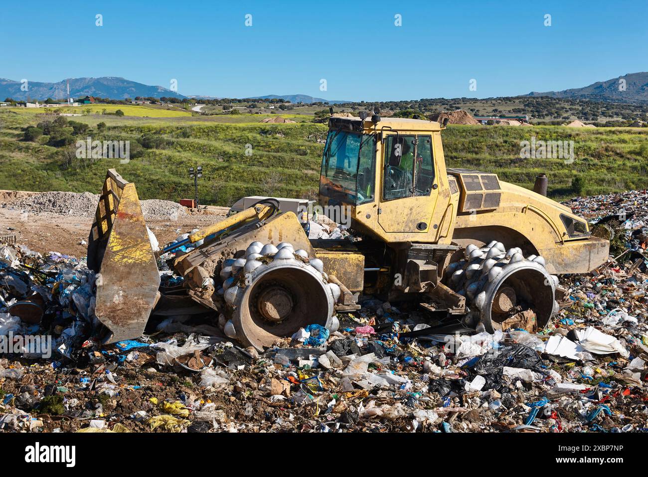Heavy machinery shredding garbage in an open air landfill. Waste Stock ...