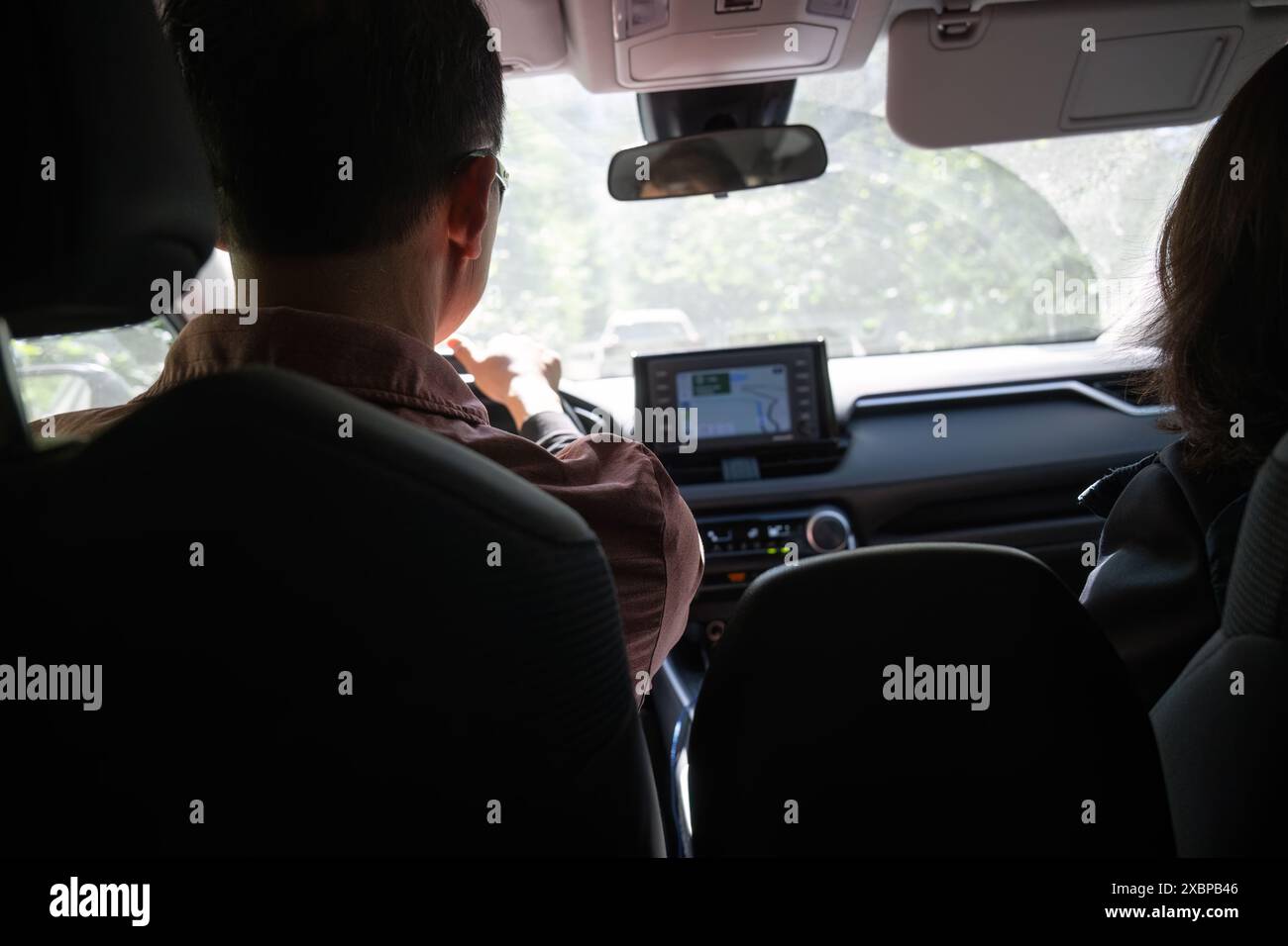 Couple driving on the gravel road full of potholes. Dust stirred up by ...