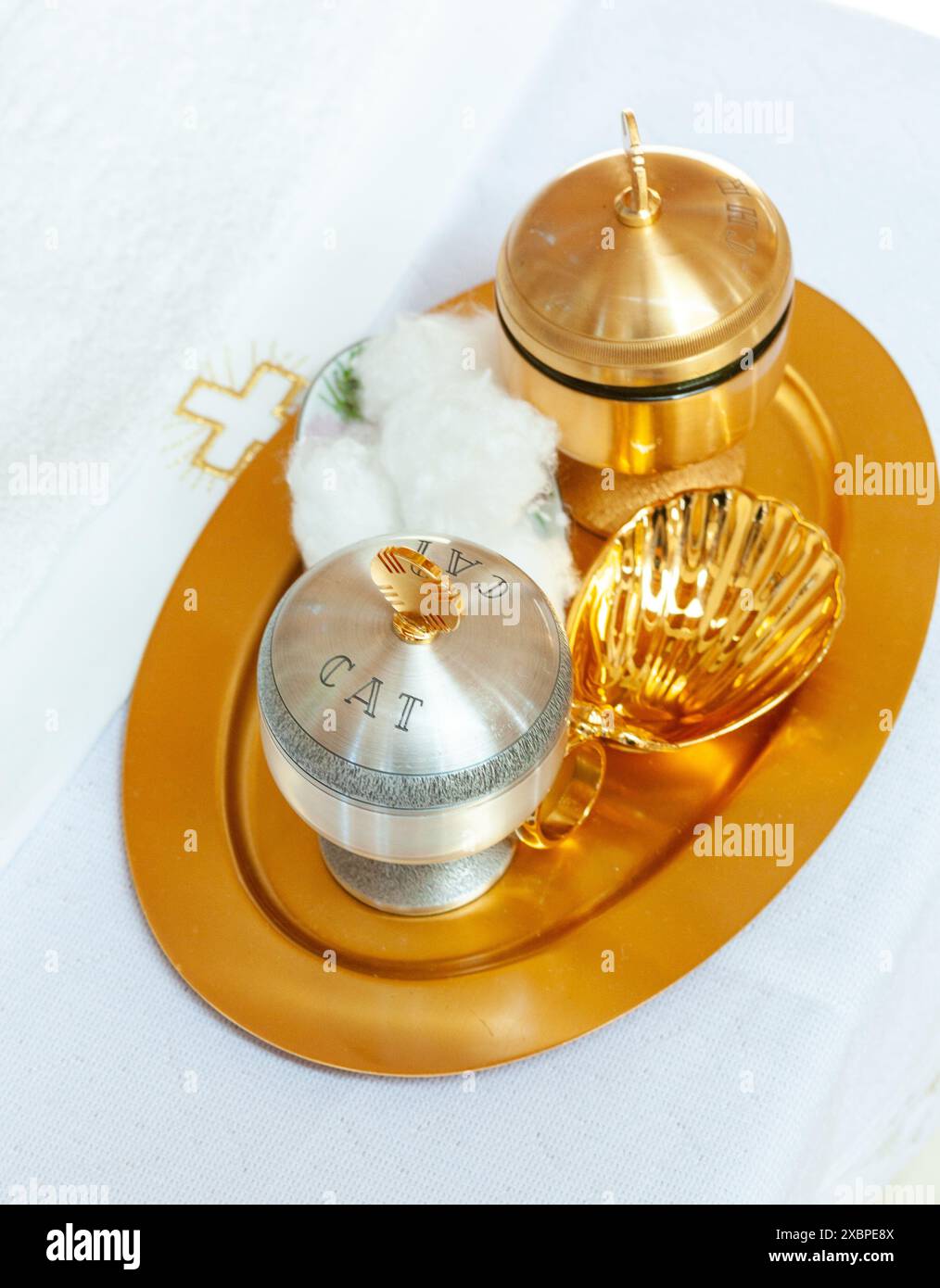 Golden tray holding the objects of the catholic baptism ceremony on an ...