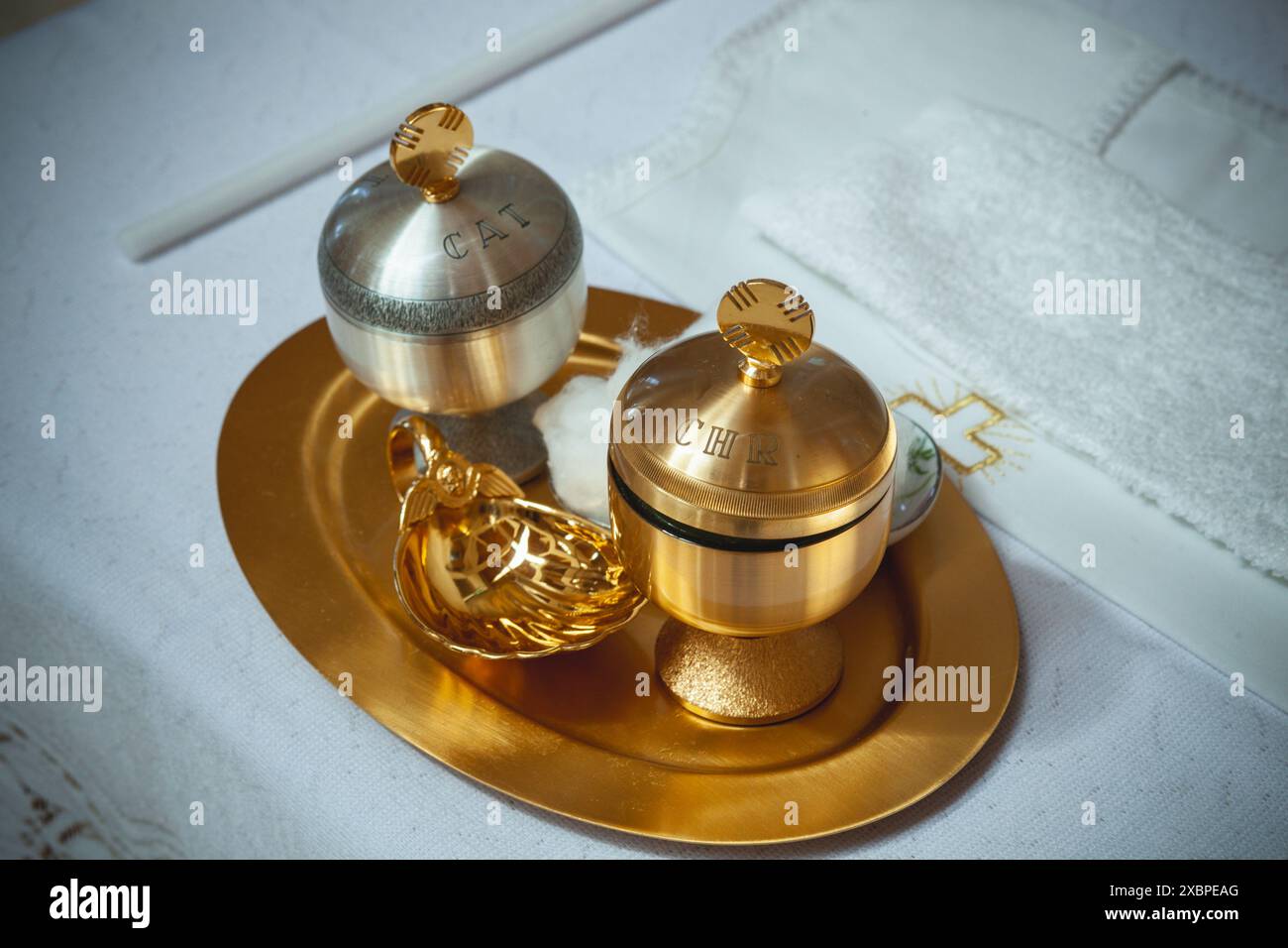 Golden chrism oil displayed on a golden tray with a golden shell for a ...