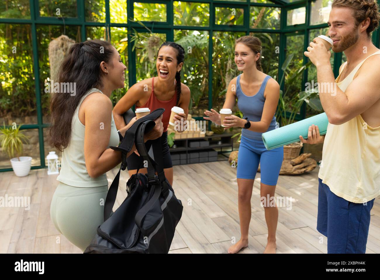 A diverse group of people at yoga class enjoy conversation while ...