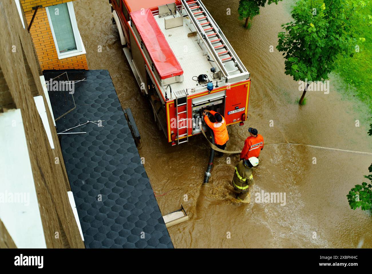 Rescuers pump out water after flooding of a flooded multi-story ...