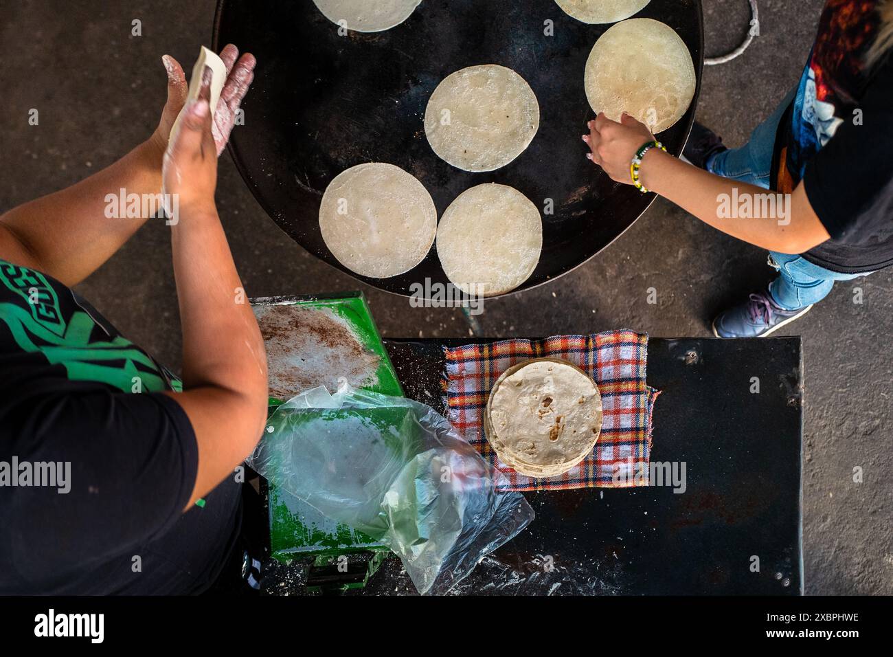 Mexican women cook tortillas on the comal in a tortillería in Morelia ...