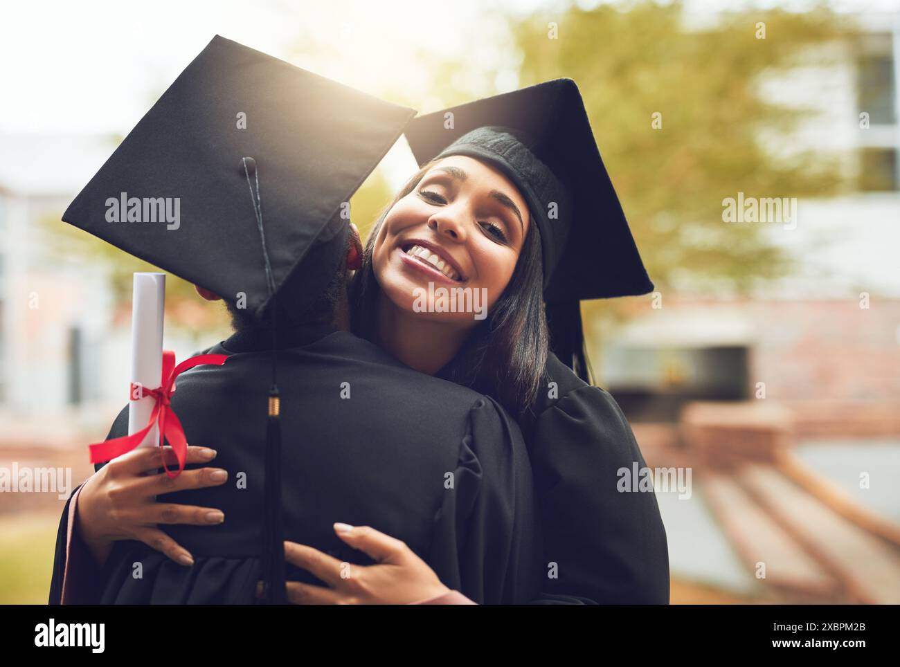 Graduation, people and excited or hug for celebration outdoor on campus ...
