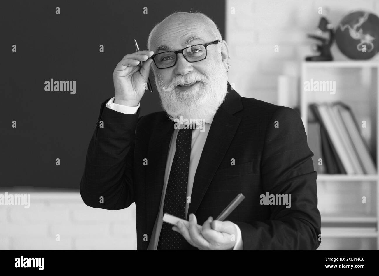 Elderly professor, teacher on a blank chalkboard during lesson. Senior ...