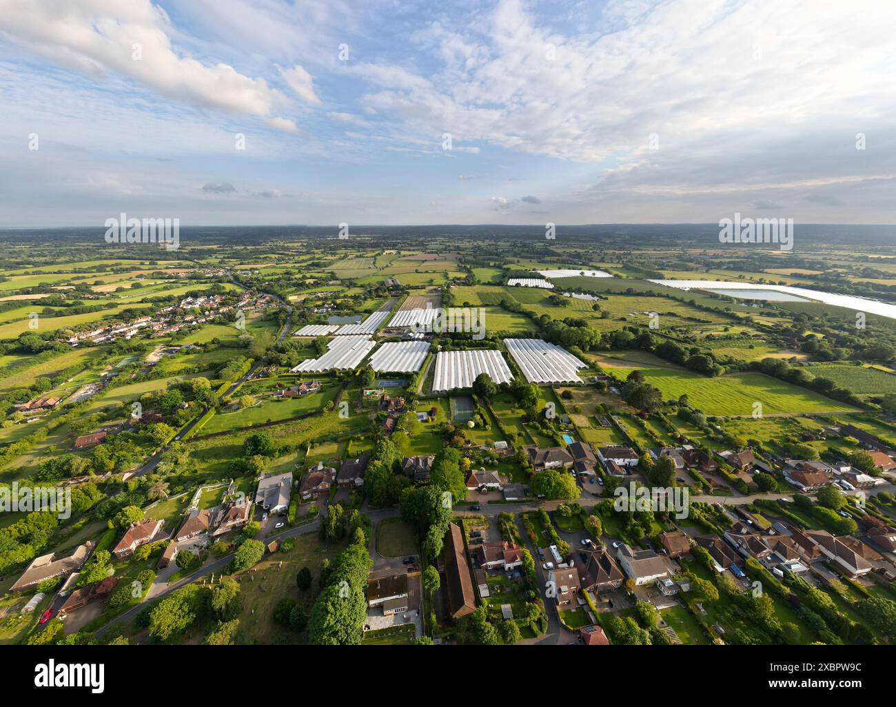 High drone view of farmland and plastic tunnels across the Weald of ...