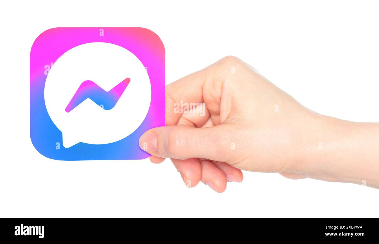 Hand holds paper Facebook Messenger mobile app icon, on a transparent ...