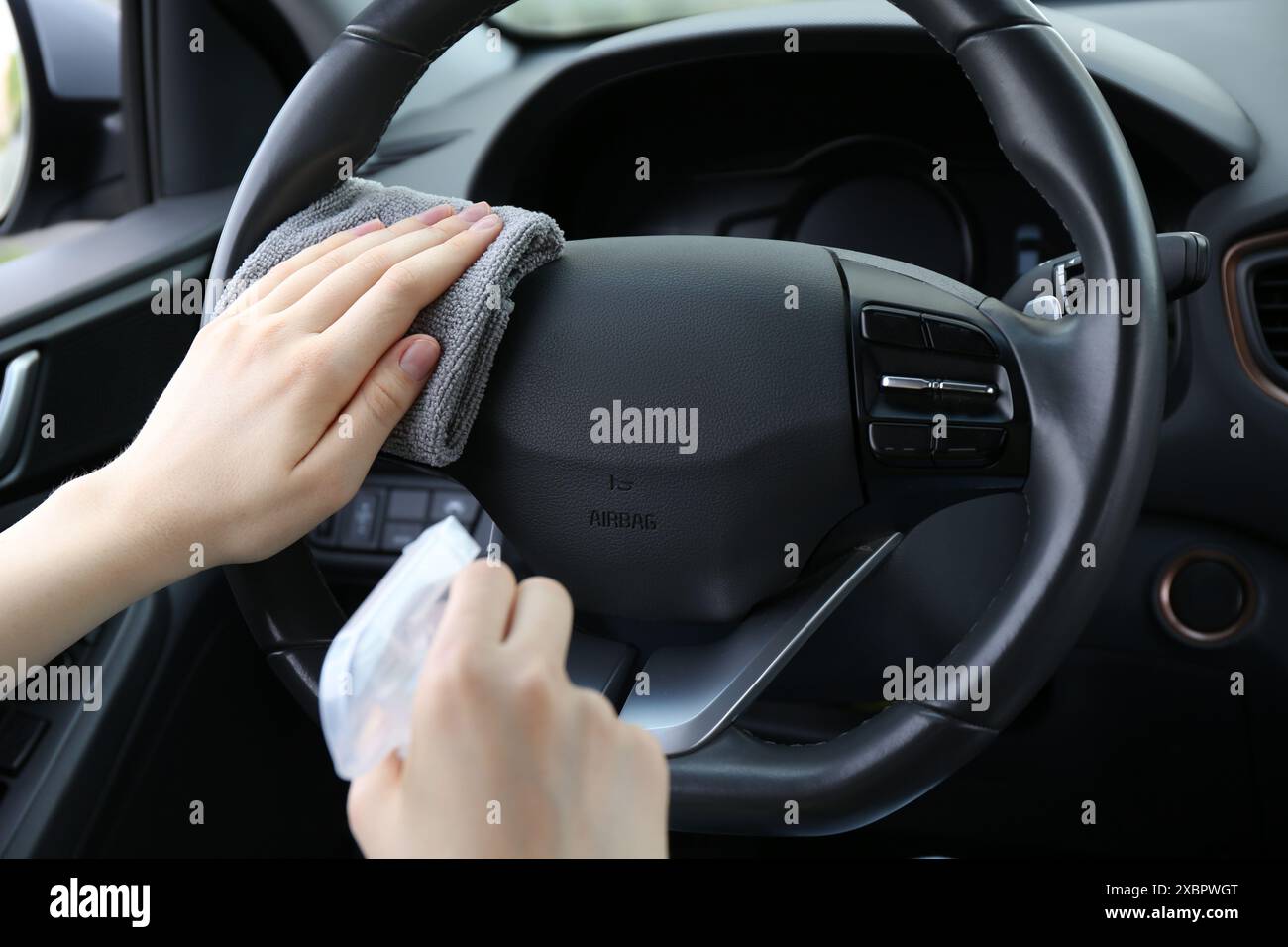 Woman cleaning steering wheel with rag in car, closeup Stock Photo - Alamy