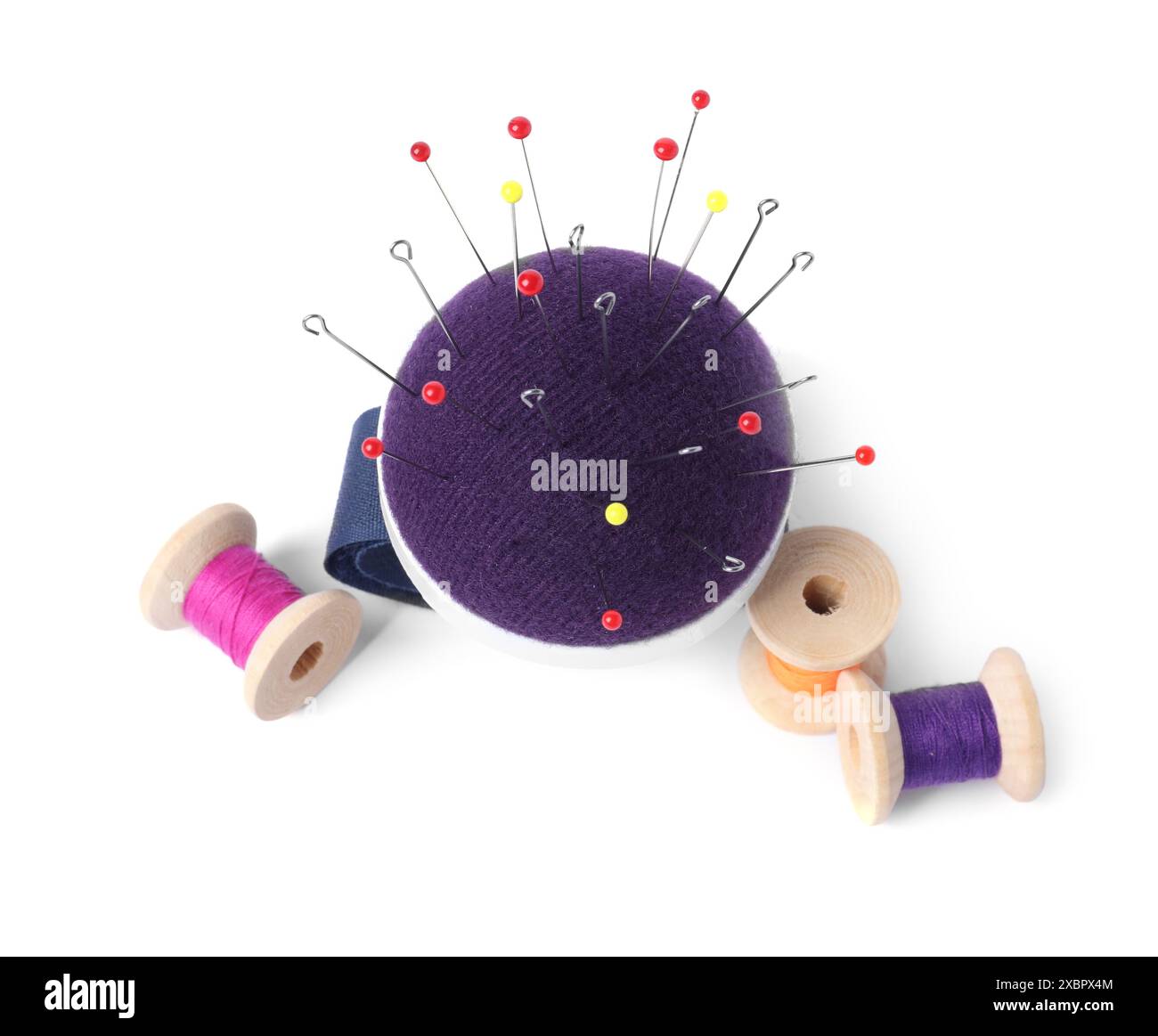 Blue pincushion with sewing pins and spools of threads isolated on ...