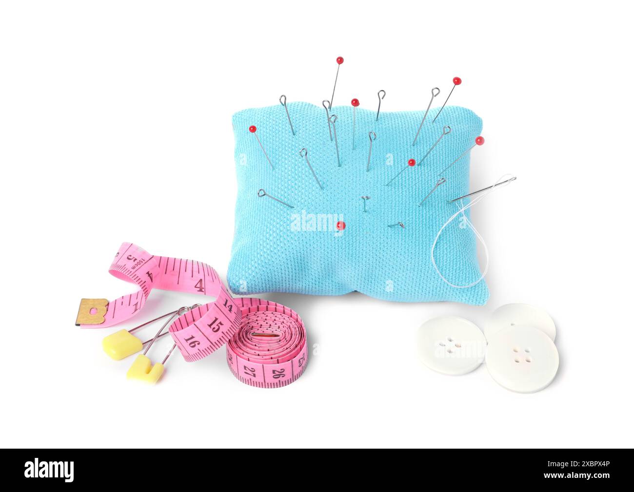 Light blue pincushion with sewing pins, measuring tape and buttons ...