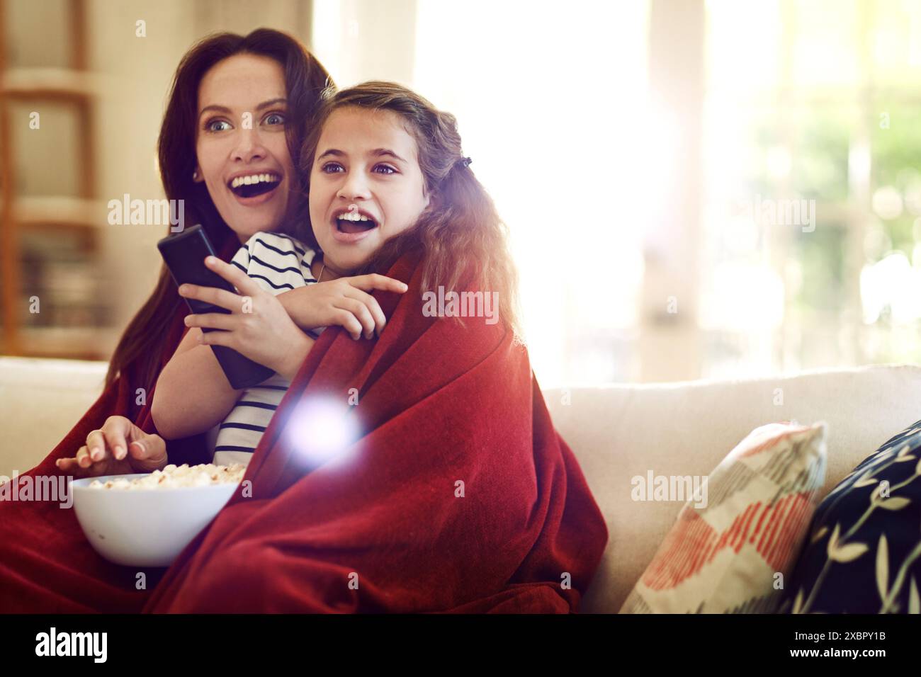 Girl, mother and shock on sofa with movie or popcorn, entertainment and ...