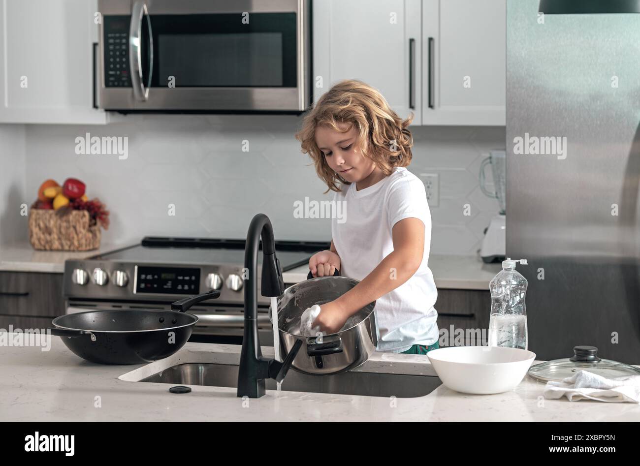 Boy washing dishes in sink hi-res stock photography and images - Alamy