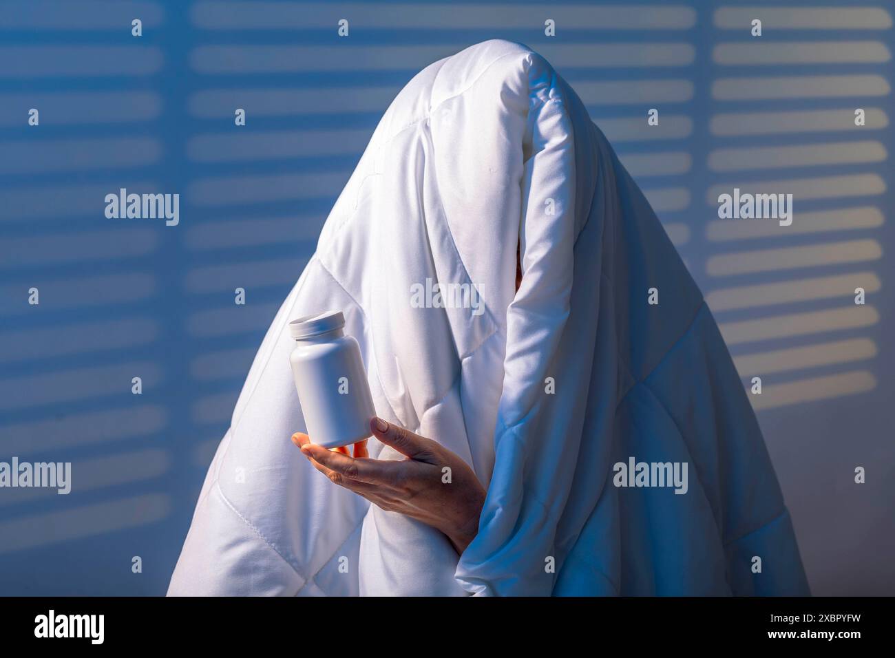 Sleeping capsule with in hand, unrecognizable man under a blanket ...
