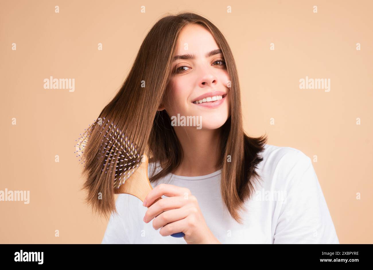 Beautiful woman combs her healthy hair. Combing healthy long straight ...