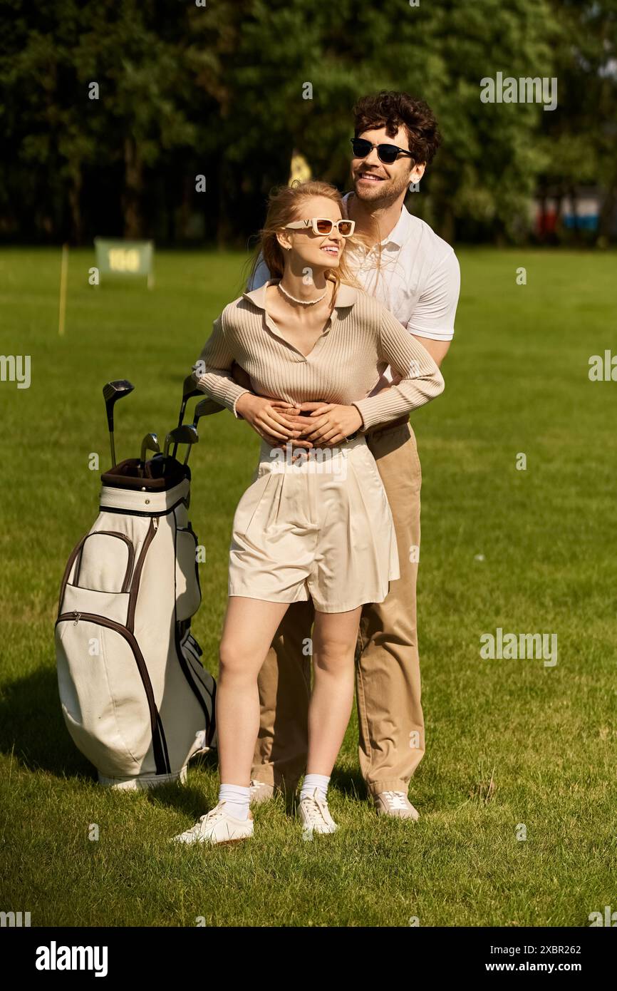 A young couple in elegant attire standing together on a lush green golf ...