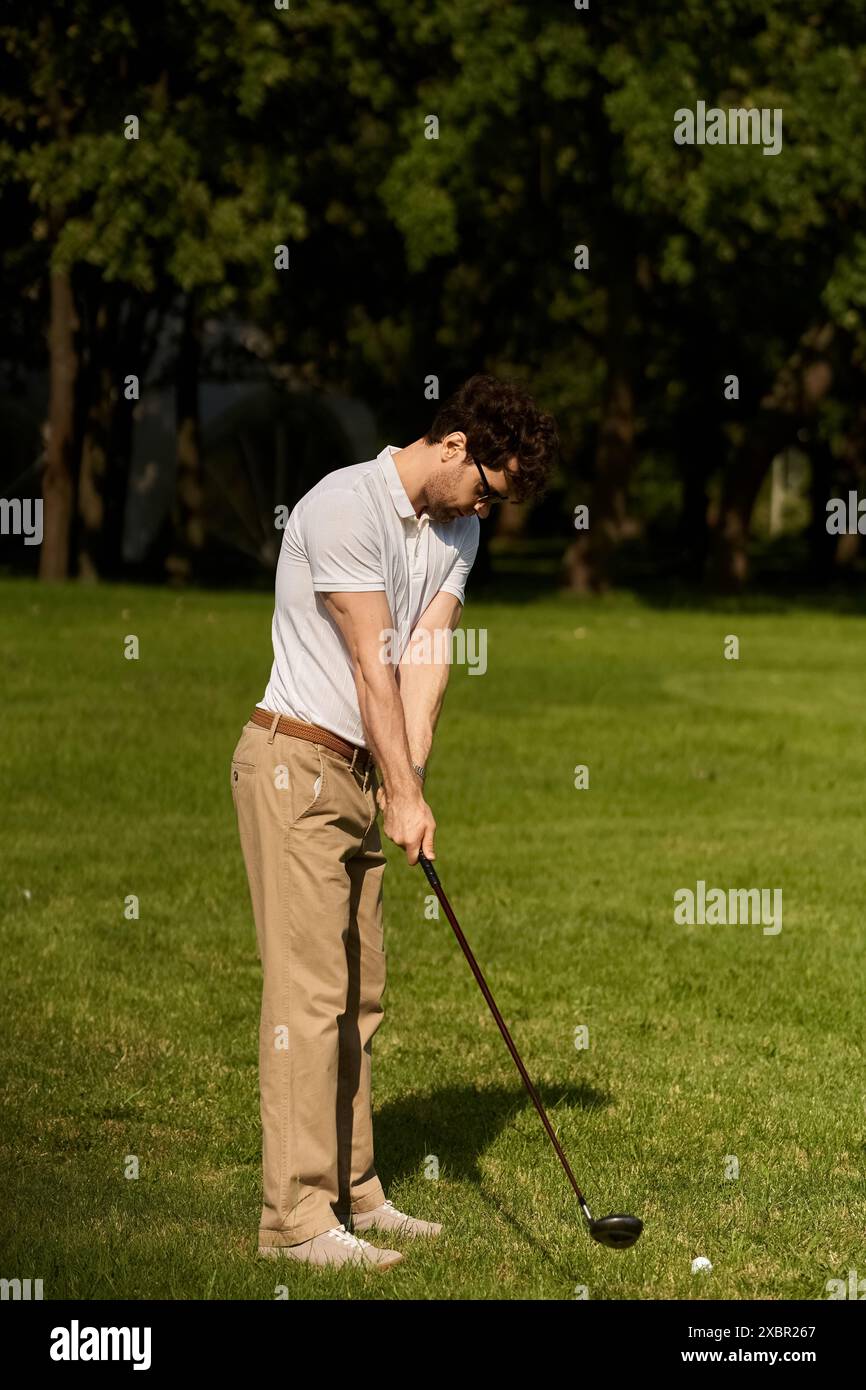 A man in elegant attire swinging a golf club, hitting a ball on a lush ...