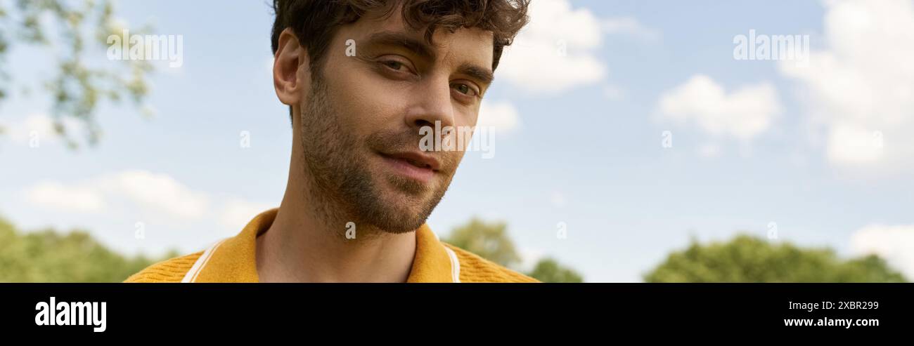 A man in a yellow shirt stares at the camera, his expression intense ...