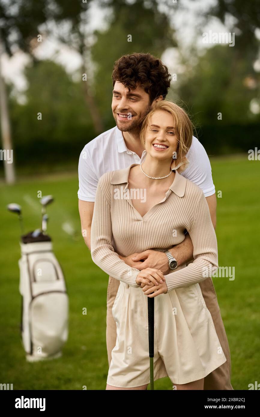 A stylish couple in formal attire posing on a golf course surrounded by ...