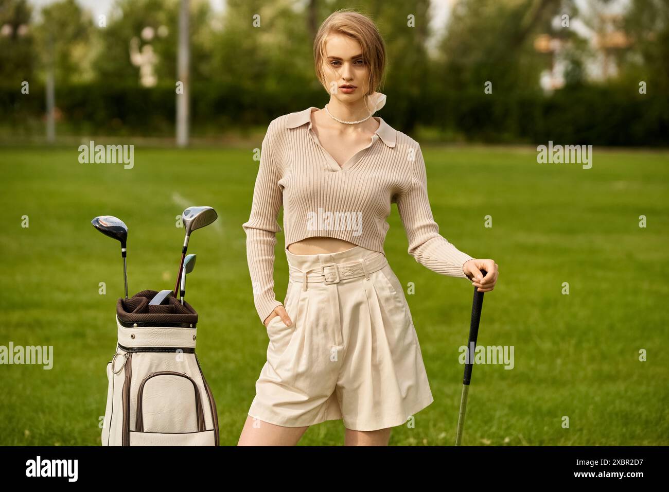 A stylish young woman in elegant attire poses gracefully with a golf ...