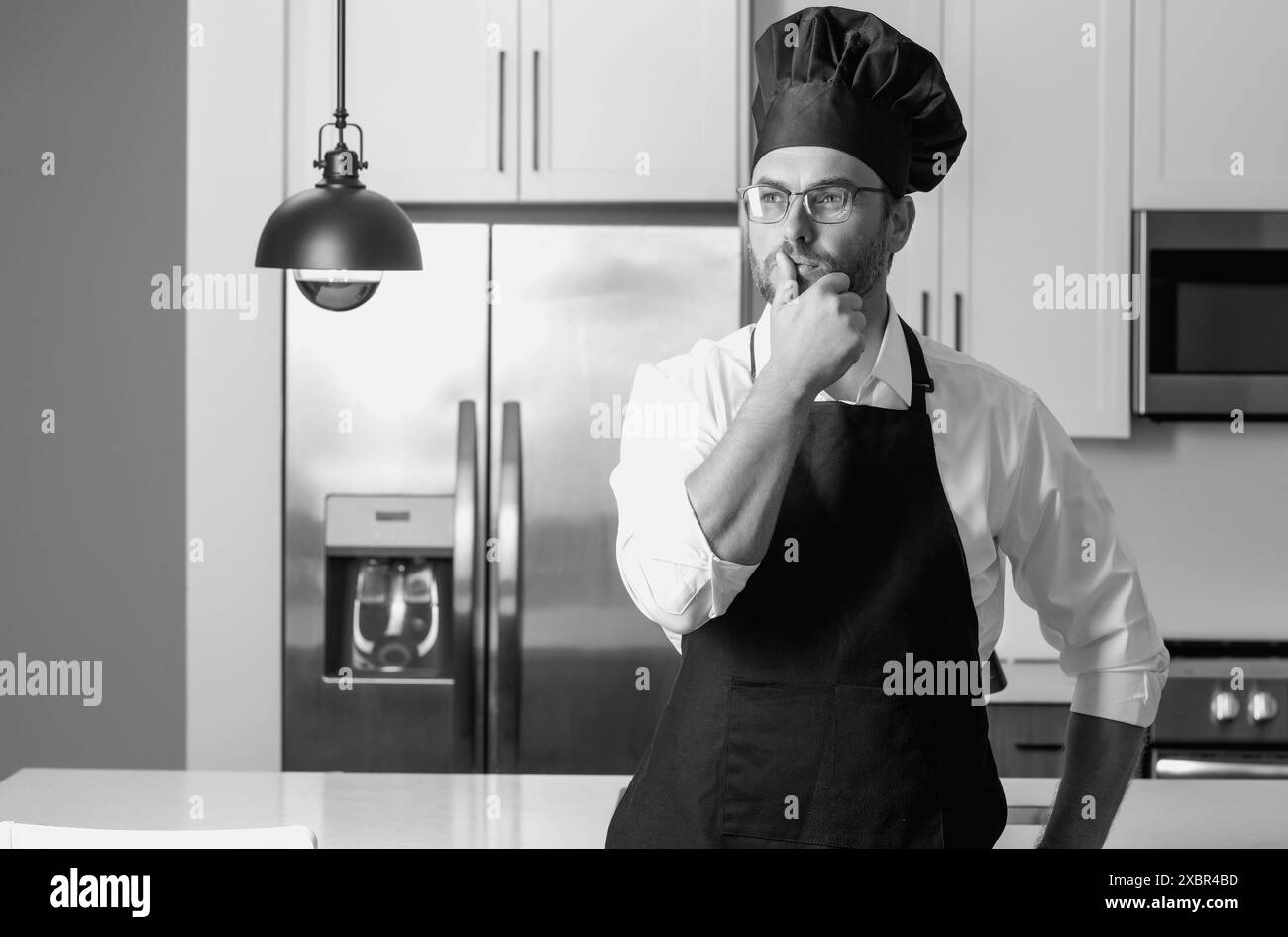 Portrait of chef man in a chef cap in the kitchen. Man wearing apron ...