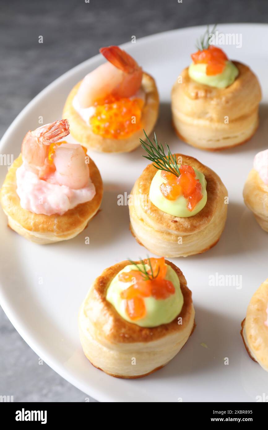Different delicious puff pastry snacks on stand Stock Photo - Alamy