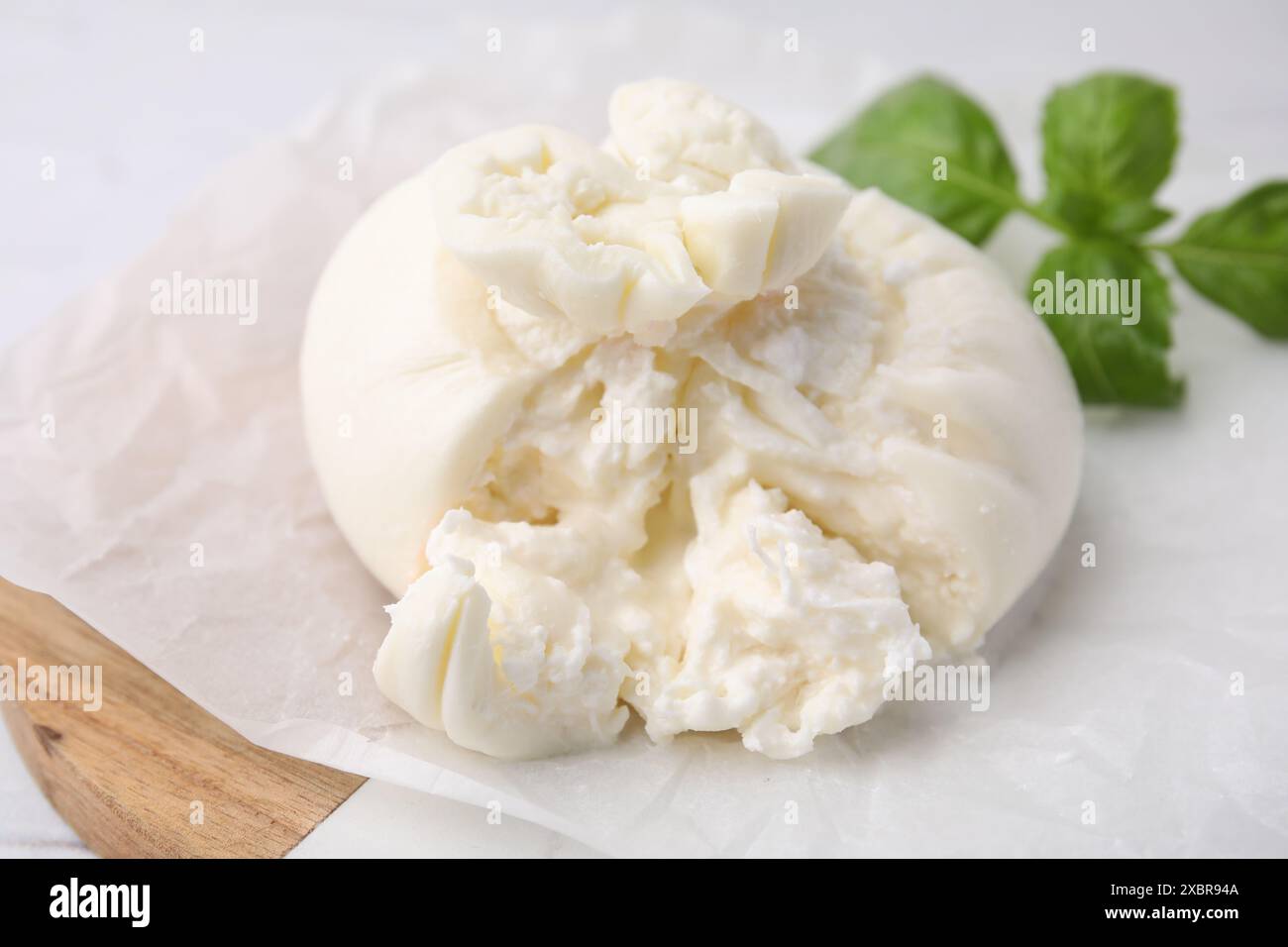 Delicious fresh burrata cheese on white table, closeup Stock Photo - Alamy