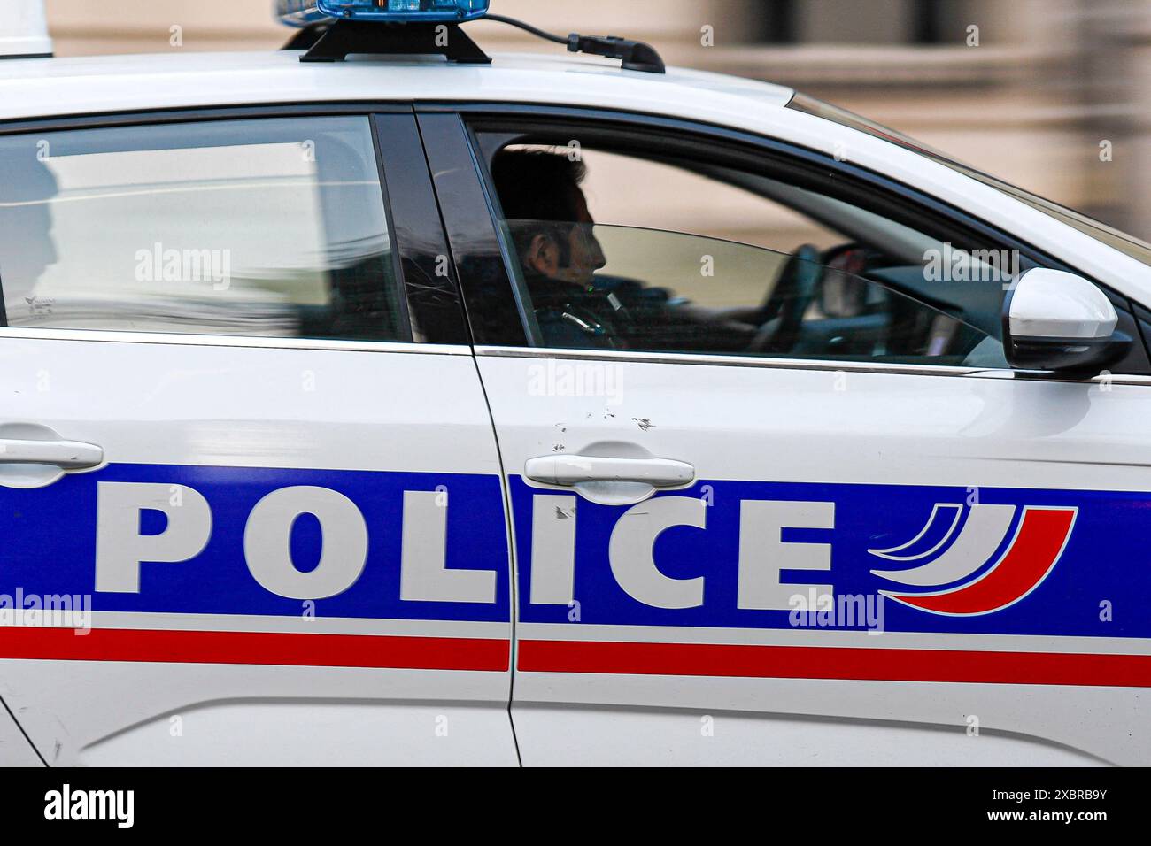 A police car (truck, van) drives through the city ensuring security in ...