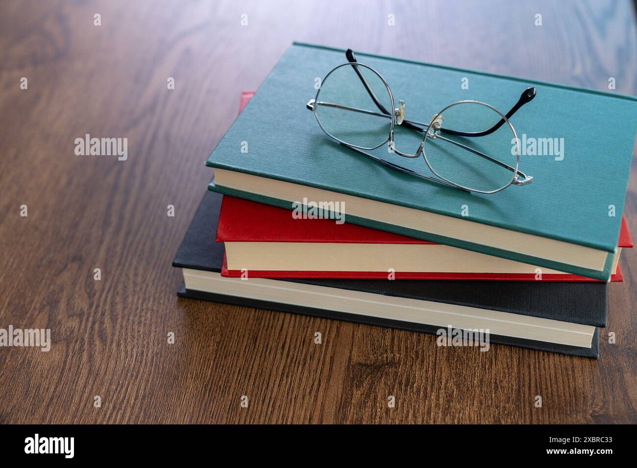 Eyeglasses resting on a stack of books Stock Photo - Alamy