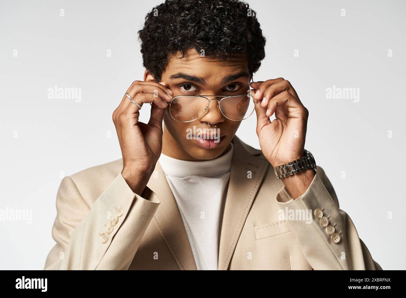 Young man in tan suit putting on stylish glasses Stock Photo - Alamy