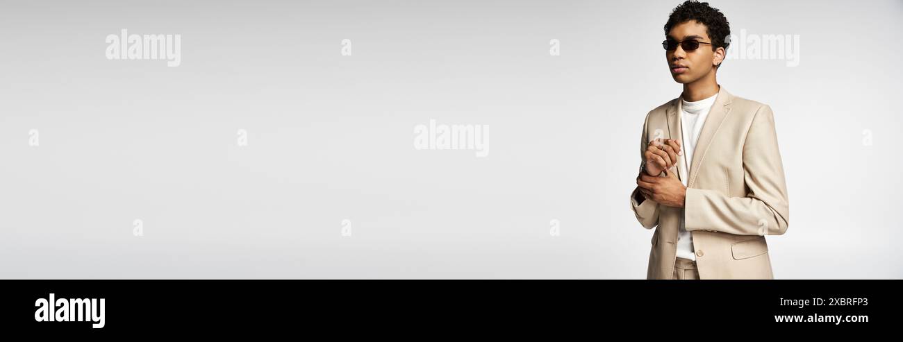 Handsome man in tan suit strikes a stylish pose, wearing sunglasses ...