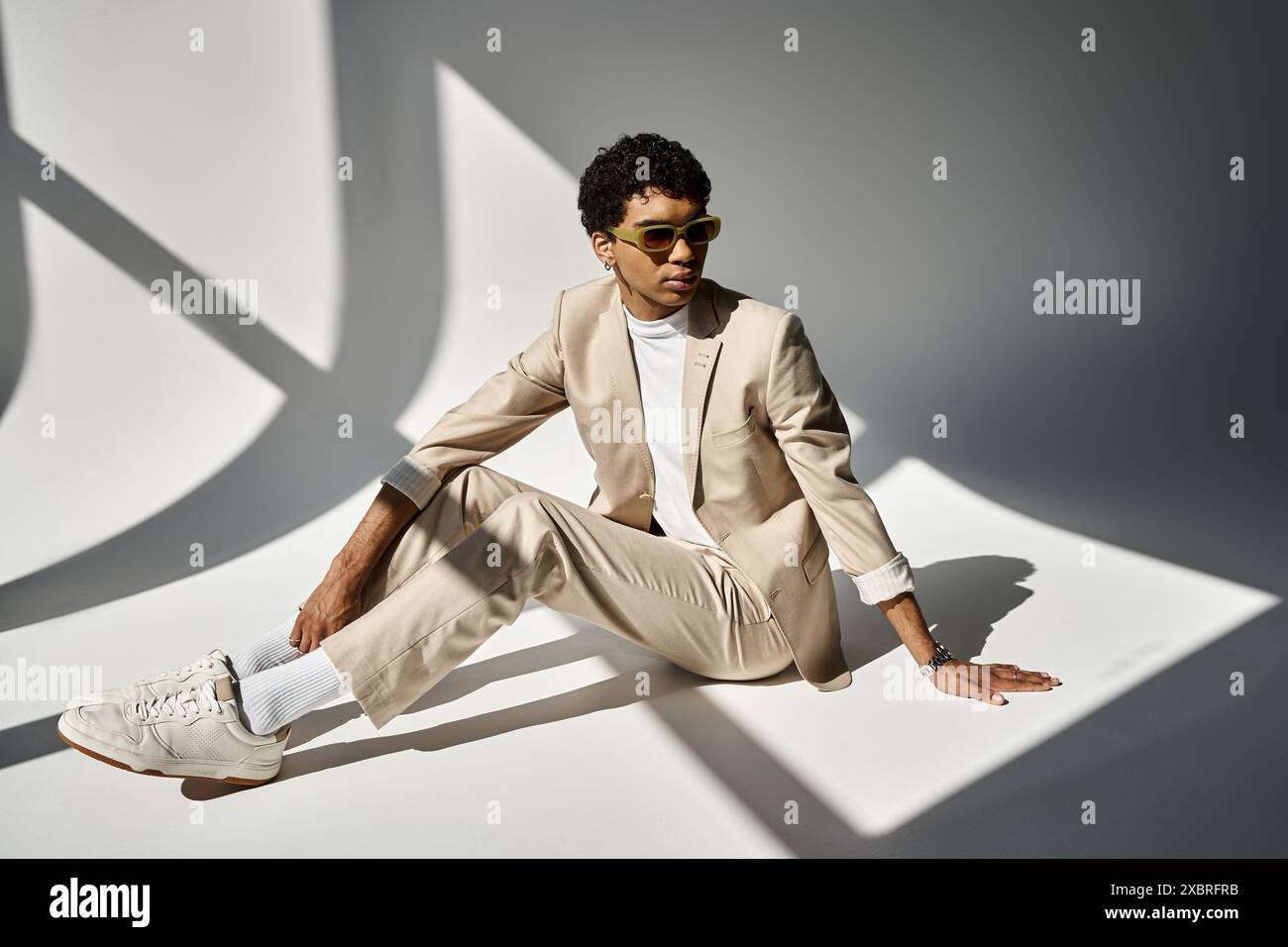 African American man in tan suit sitting on floor, wearing sunglasses ...