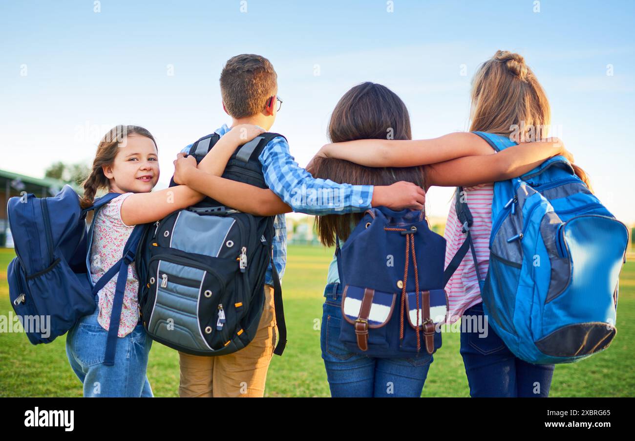 School kids, support and back with hug, grass and together with ...