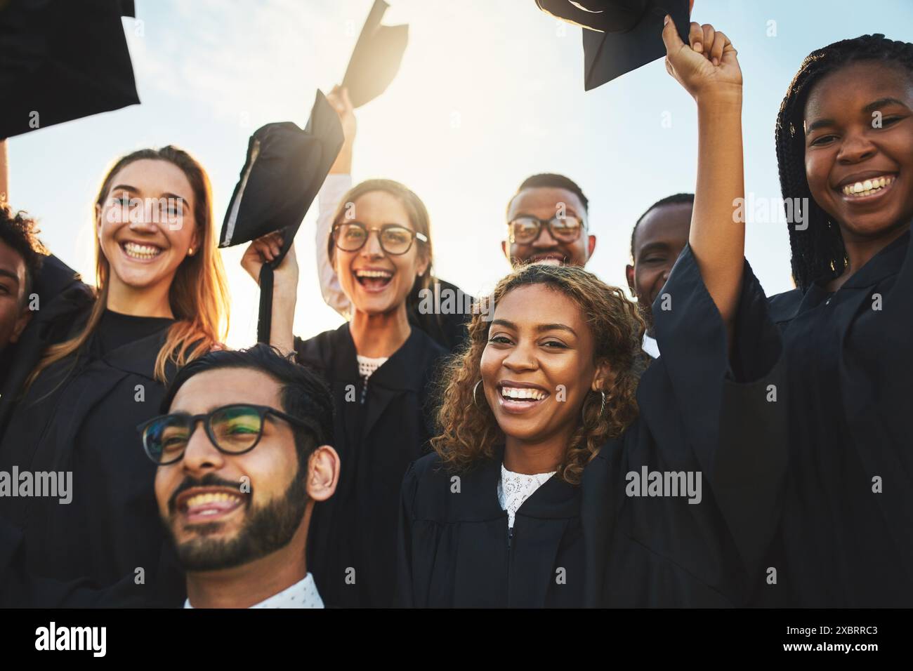 Group, graduates and diversity at university graduation, happiness for ...