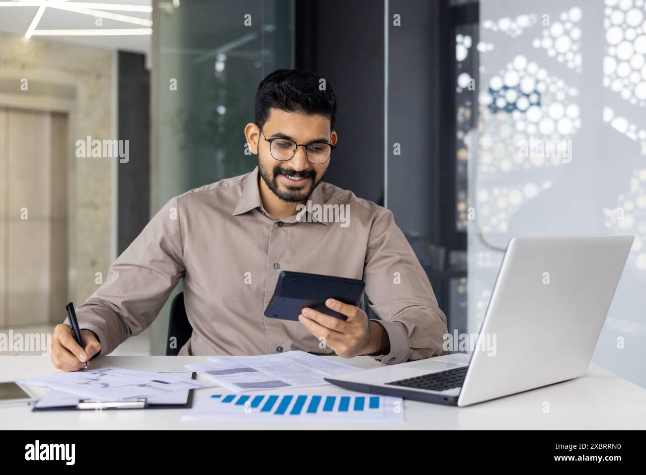 Smiling young Indian male accountant, financial expert and analyst ...