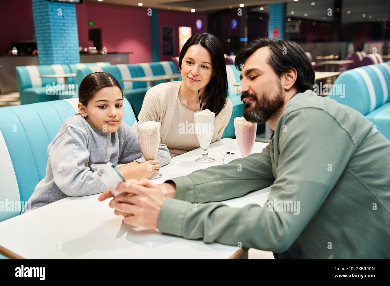 A cheerful family enjoys a meal together in a stylish restaurant ...