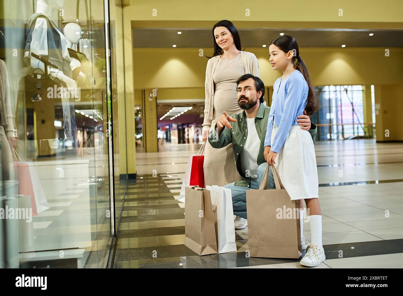 A happy family exploring a shopping mall, holding multiple shopping ...